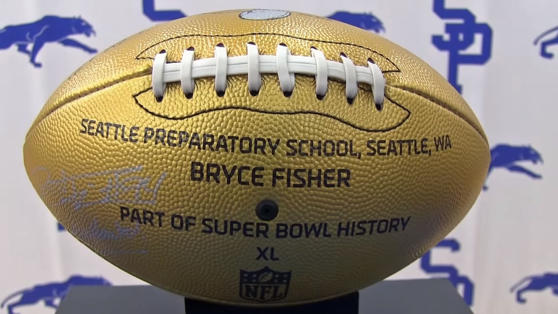 Bryce Fisher presents Seattle Prep with Golden Football | king5.com